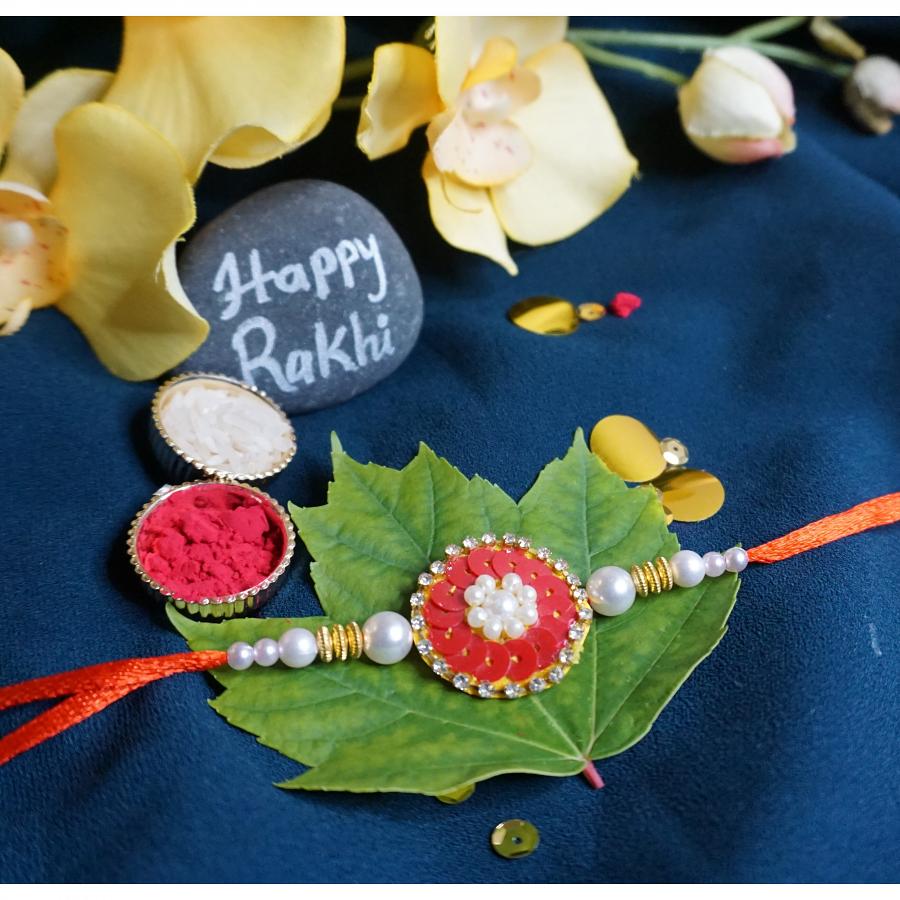 Beautiful Red Flower Rakhi W/ an embedded Emerald like Pearls + Roli ...